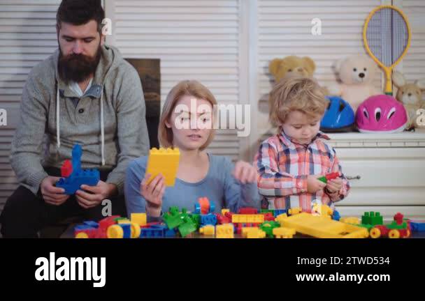 Young family play game with construction plastic blocks. Family games ...