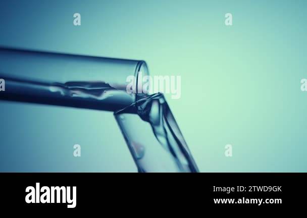 Transparent fluid flows from one test tube into another in a ...