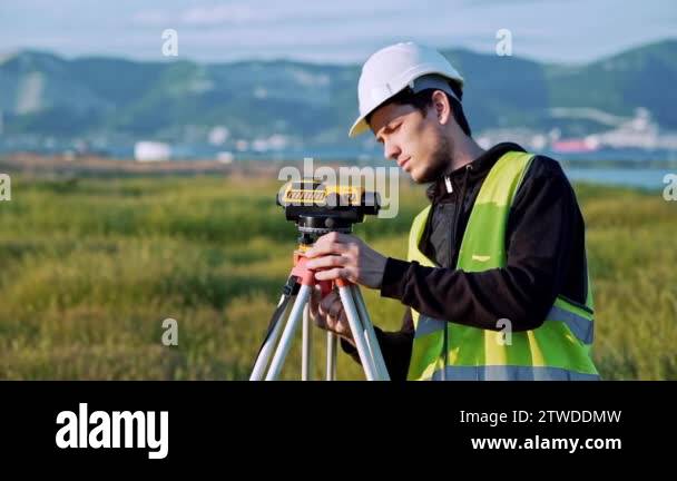Surveyor engineer is measuring level on construction site. Geodesist ...