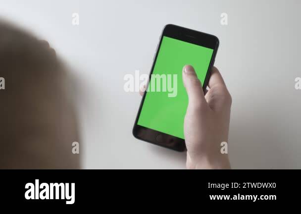 Mens hands hold a big black smartphone making pinch to zoom gesture ...