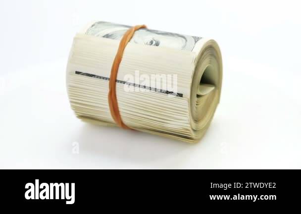 Rotating rolled up bundle of 100 dollar notes on a white background ...