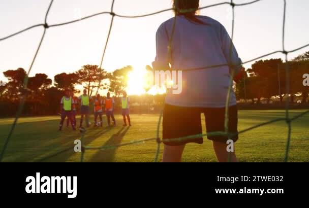 Rear view of Caucasian female keeper trying to stop the ball while ...
