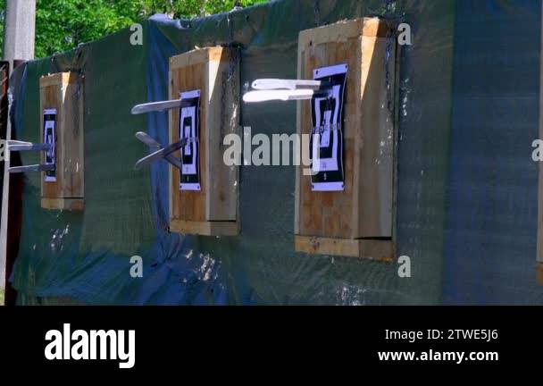 Throwing knives at the target from an open-air distance, a competition for throwing knives ...