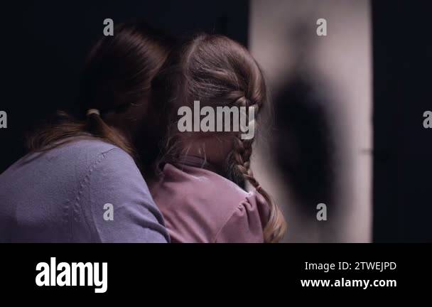 Scared woman hugging child, afraid of cruel criminal silhouette ...