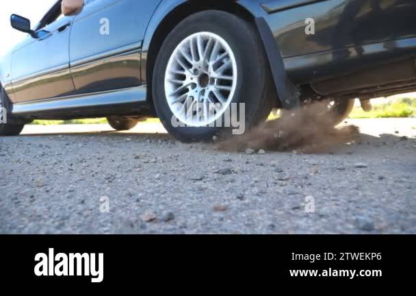 Wheel of car are slip on a asphalt road during start of movement. Small ...