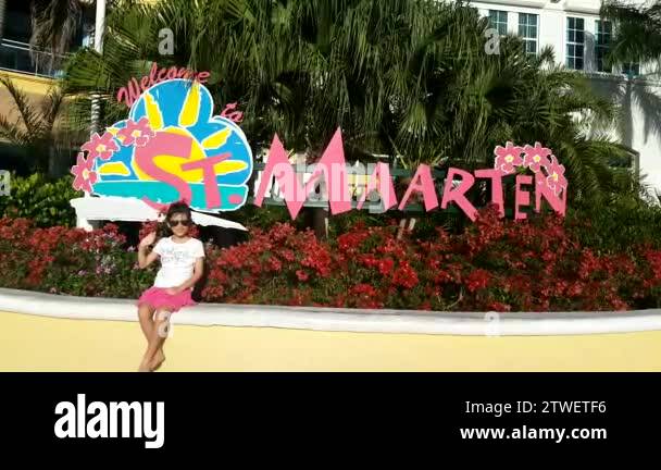 ST MARTIN-FEB 9: Little tourist saying hi to the Welcome Signboard of ...