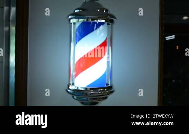 Barber pole rotating on wall in hairdresser shop. Barber pole spinning ...