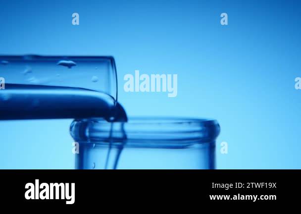 Clear water flows from a narrow tube into a wide one in a chemical lab ...