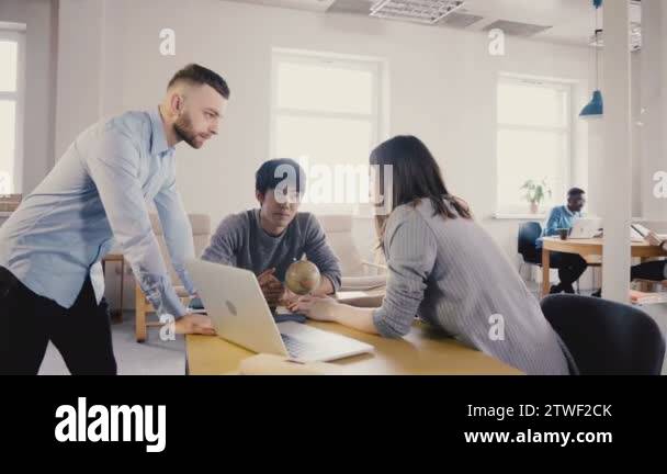 Camera follows Caucasian manager coming up and talking to colleagues ...