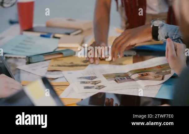 Close-up multiethnic development company partners collaborate, work together over office table ...