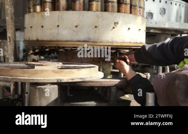 Worker is unscrew the screw under machine.Worker is disassembly mechanism of obsolete machine ...