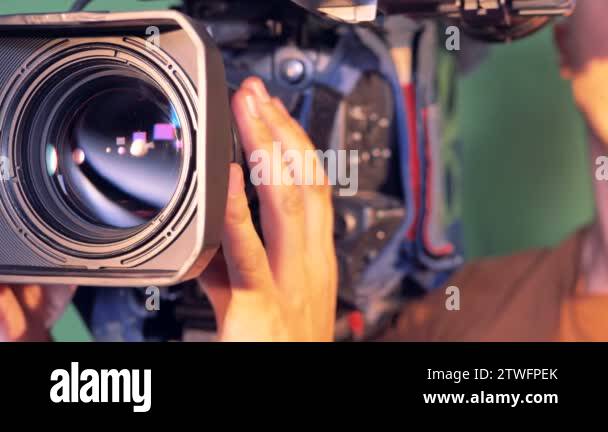 Operator is holding a video camera, turning it thereafter it is zooming ...