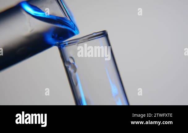 Blue liquid is poured from one tube into another in a modern medical ...