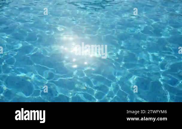 Sunny cross is seen on the swimming pool water in summer in slow motion ...