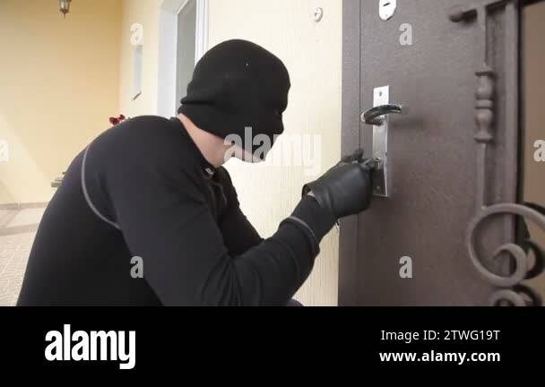 burglar holding Lock-picker to open a housedoor The thief breaks the ...