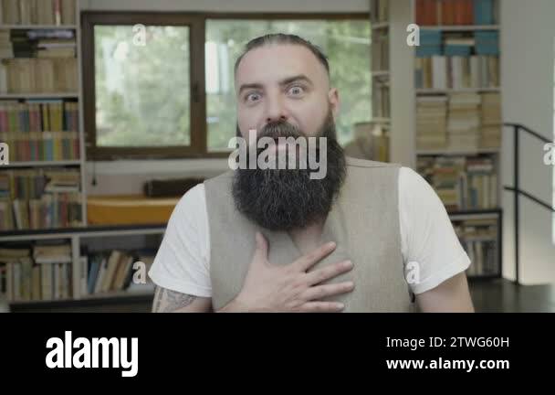 Amazed surprised reaction of a young man saying wow and putting hand on ...