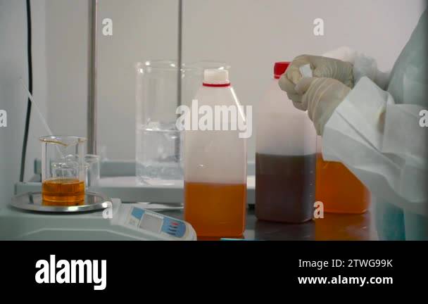 The worker measuring liquid on the scales and it is too much and hes ...