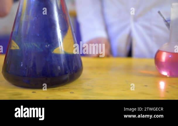 Flask with acid and blue reagent Stock Video Footage - Alamy