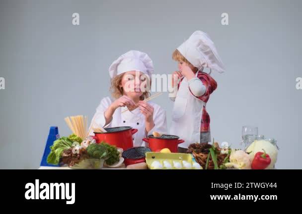 Cute little boy and his beautiful mother smiling while cooking in ...