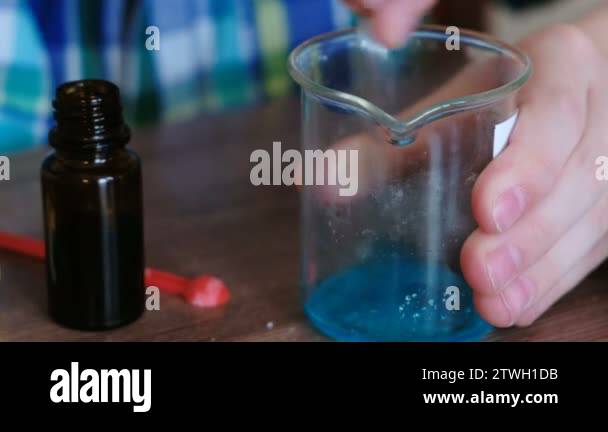 Experiments on chemistry at home. Closeup boys hands mixes the ...