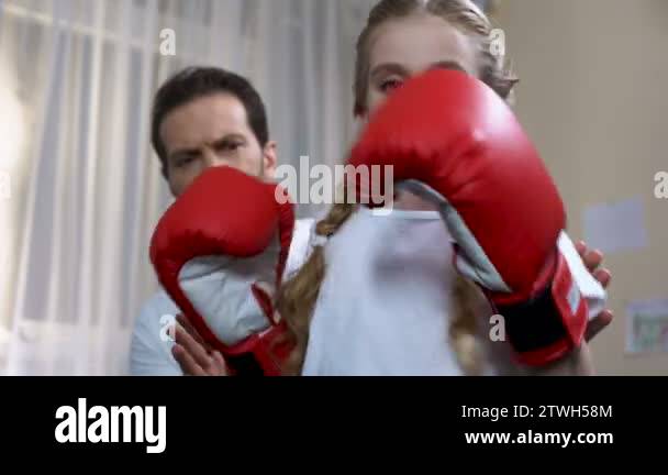 School girl in boxing gloves punching and showing yes gesture with ...