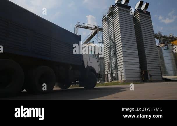Panorama of grain trucks driving to unload at silo on elevating ...