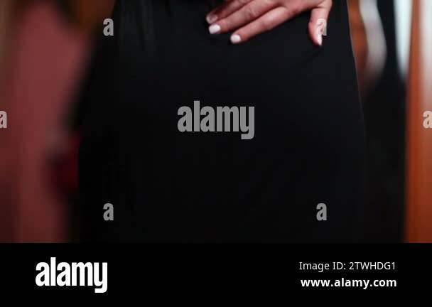 Closeup backside view woman tries to zip black and white dress and ...