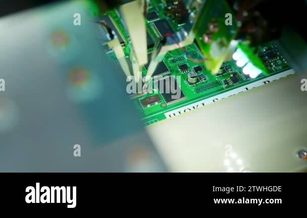 Factory Machine At Work Printed Circuit Board Being Assembled With Automated Robotic Arm