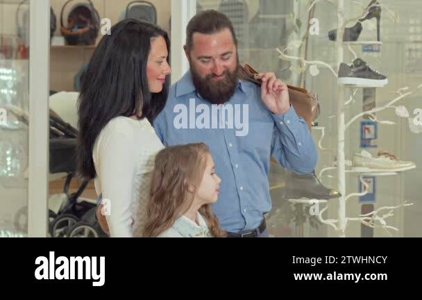 Lovely family looking at the display of clothing store at shopping mall ...