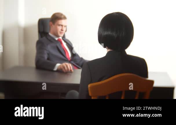 a man in a suit asks questions to a brunette woman in an interview. 4k ...