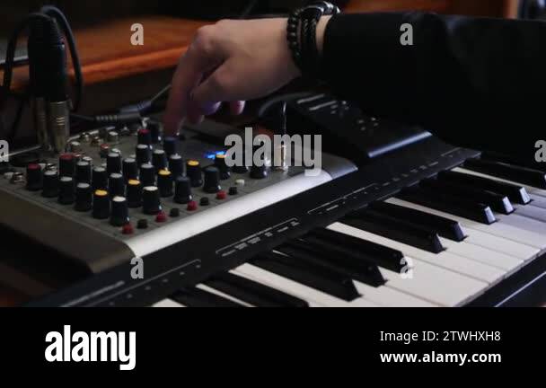 Sound engineer mixing and mastering a song on mixer board. Home studio ...