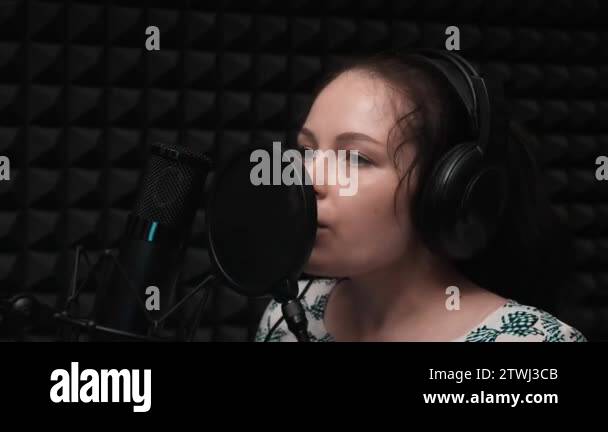 Girl sings song and shows emotions. Cute girl at recording studio ...