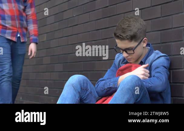 Teenage student giving hand to classmate, supporting humiliated abuse ...