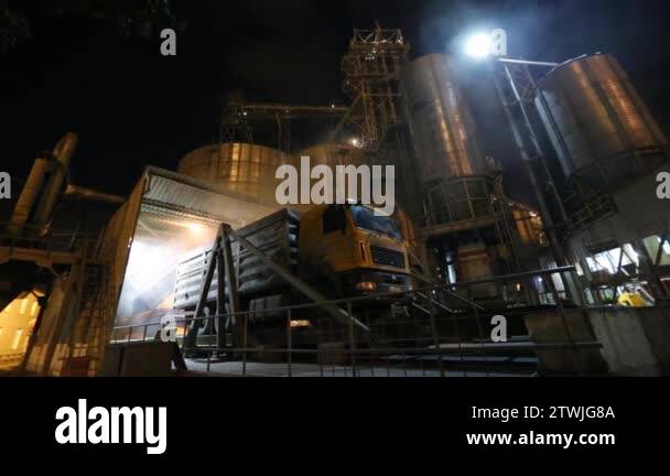 Unloading grain trucks at elevator on elevating hydraulic platform ...