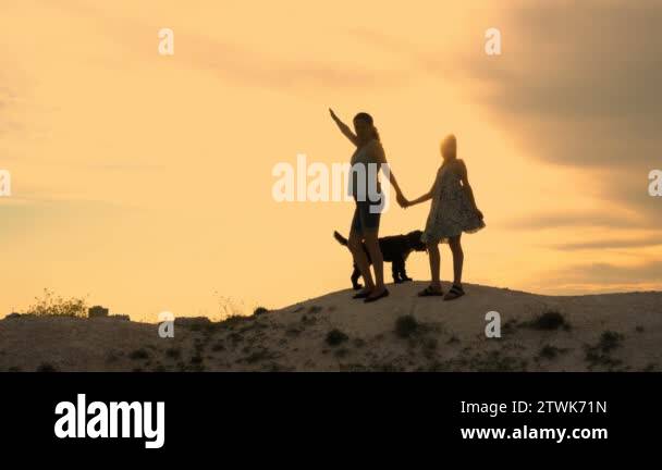 Happy family: mom, little girl and their dog stand on the top of the ...