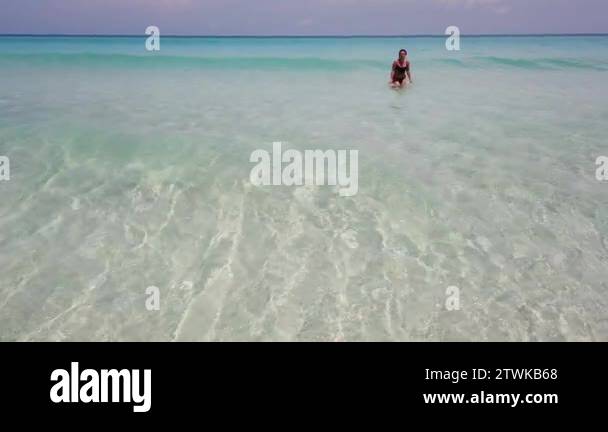 Beautiful young woman on vacation swimming in ocean on beach of ...