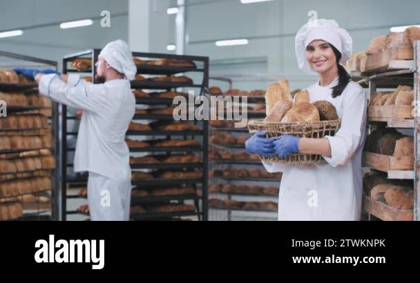 Attractive lady baker with a big basket of a fresh organic bread in ...
