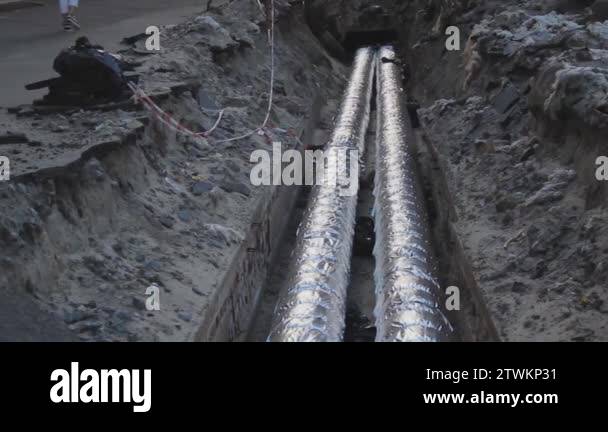 An open trench with pipes of the heating plant. Silver thermal ...
