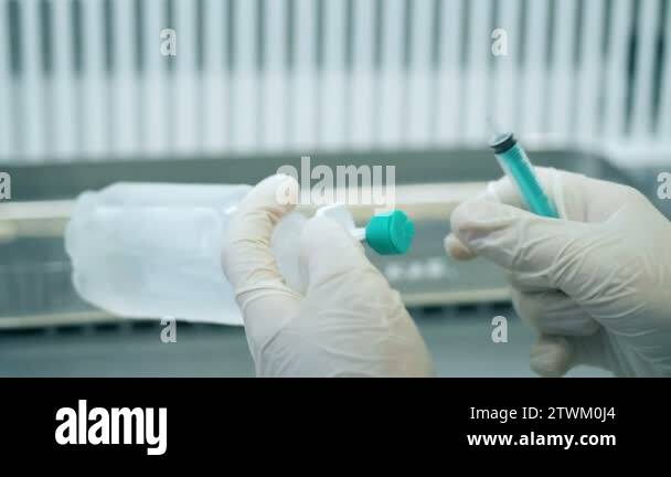 Doctor picking up medication into a syringe and prepares it for ...