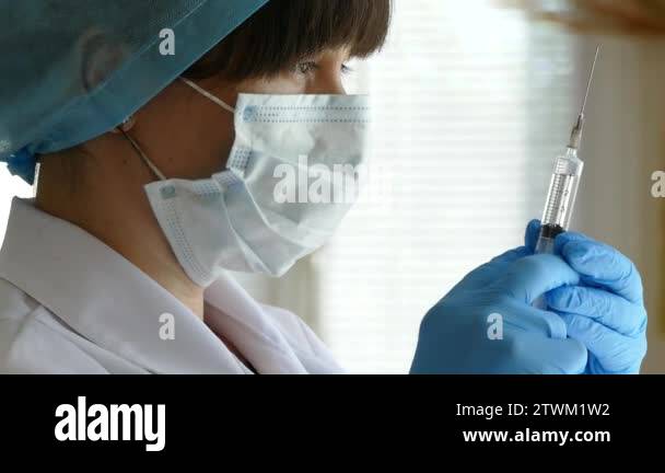 The doctor is preparing a syringe for injection. The nurse took the ...