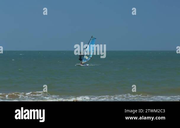 windsurfer falls down from board into ocean water and coach comes to ...