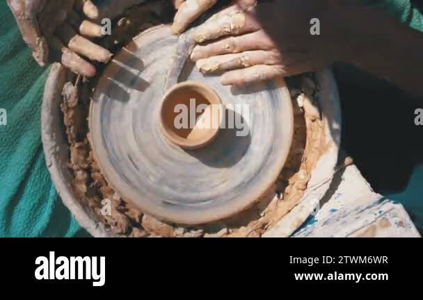 Hands of the Master Potter and Vase of Clay on the Potters Wheel close ...