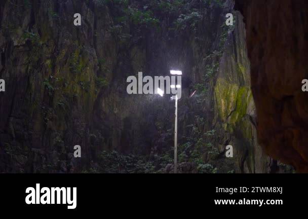 rain falling down incide of a huge Batu caves in Malaysia having a ...