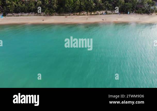 Blue lagoon and sandy beach with palms. Aerial view of blue lagoon and ...