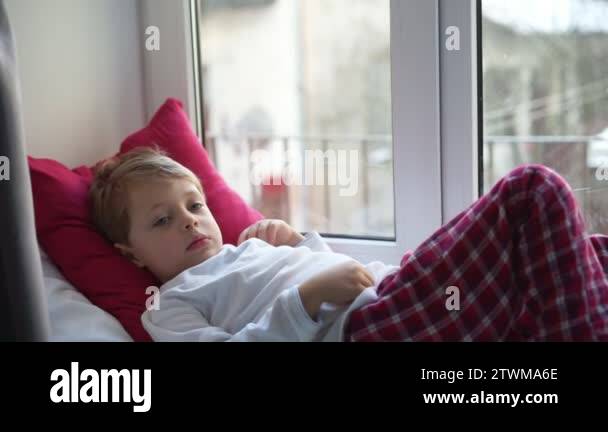 Offended little boy looking through the window Stock Video Footage - Alamy