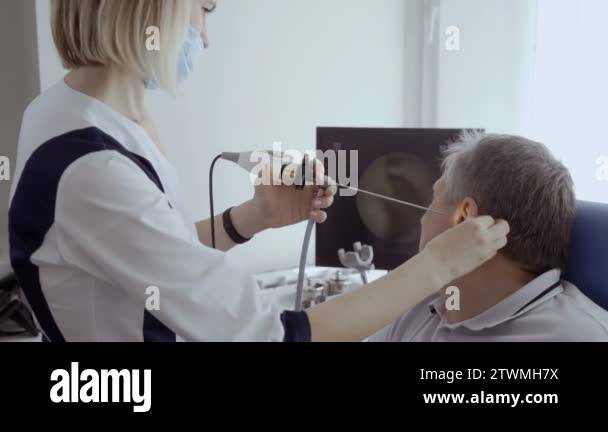 Doctor examine patient ear with ENT telescope and look at the screen of ...