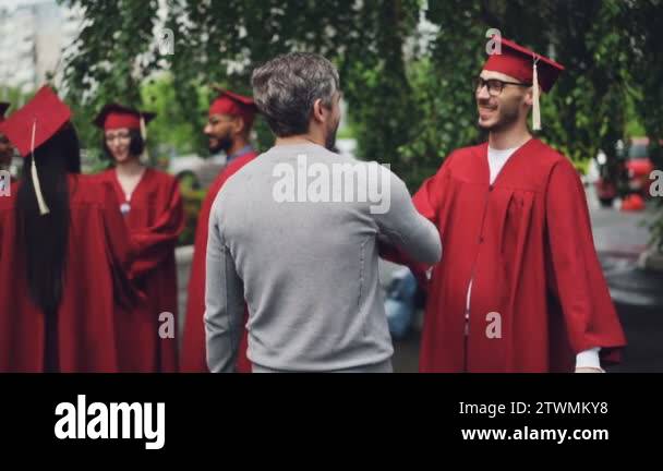 College professor is congratulating his student after graduation ...