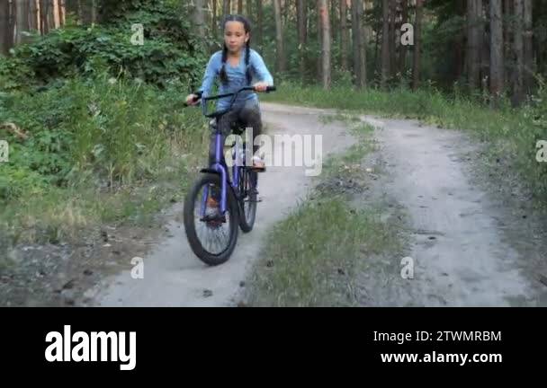 The child learns to ride a bike. The girl in the evening riding a bike ...