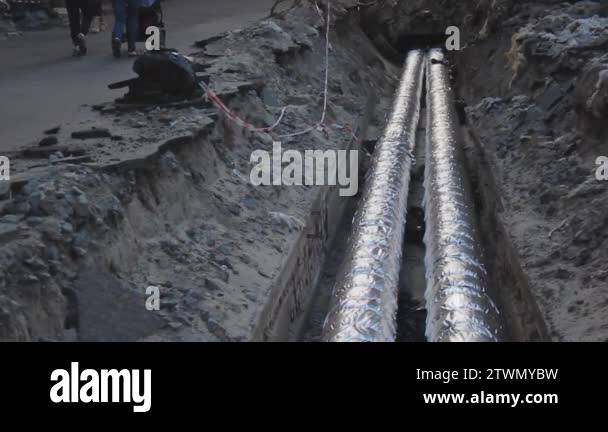 An open trench with pipes of the heating plant. Silver thermal ...