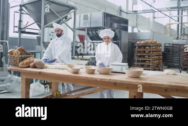 Bakery industry professional bakers forming pieces of dough for baking ...